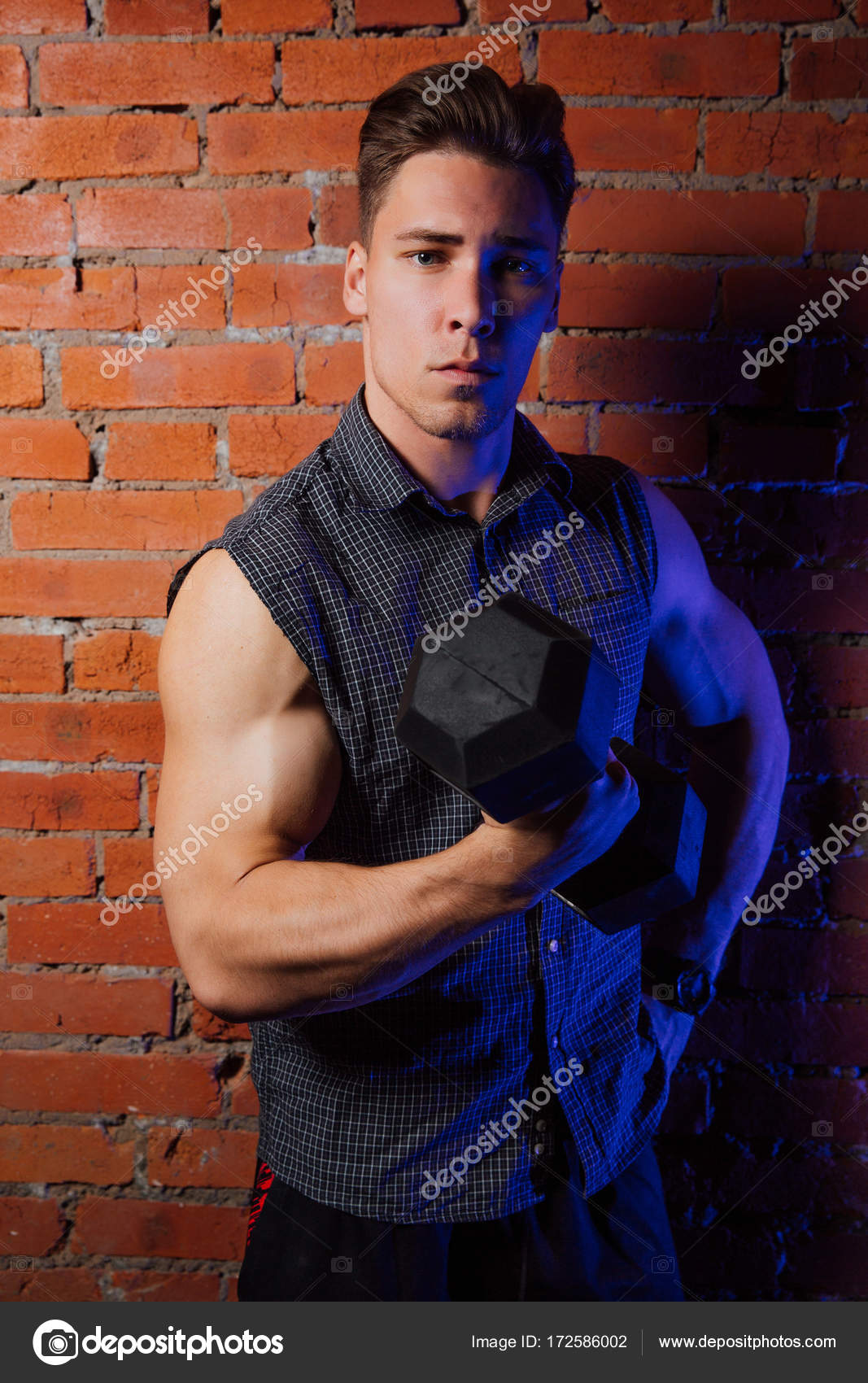 Muscular guy doing exercises with dumbbell against a brick wall — Stock ...