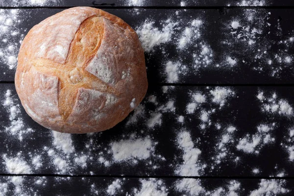 Bread with flour on a black background, wheat bread from a stove on ...