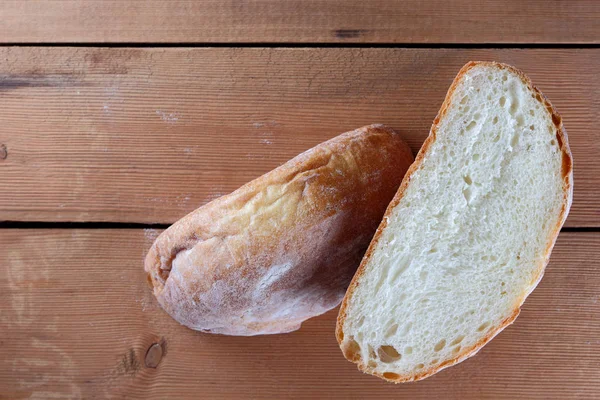Half-cut bread on a wooden background, two halves of wheat bread from a ...