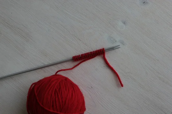 A ball of red thread and knitting needles on the table. - Stock Image ...