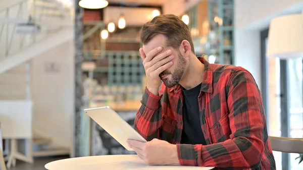 Young Man Upset by Failure on Tablet in Cafe - Stock Image - Everypixel