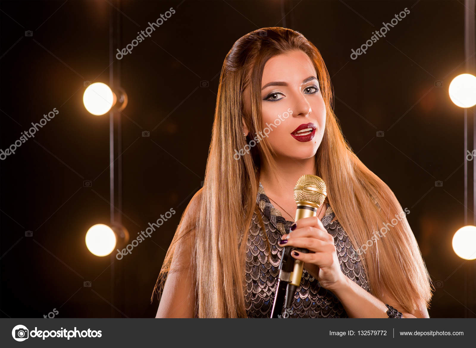 Young smiley beautiful long hair girl with microphone singing song on ...