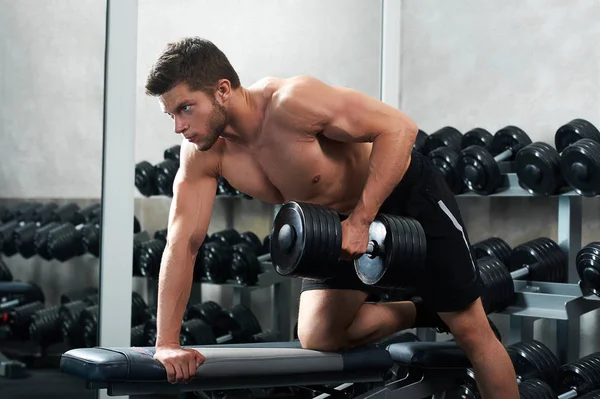 Handsome young athlete working out at the gym - Stock Image - Everypixel