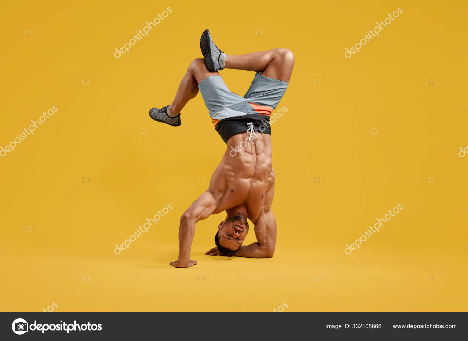 Muscular young bodybuilder performing handstand stunt Stock Photo by ...