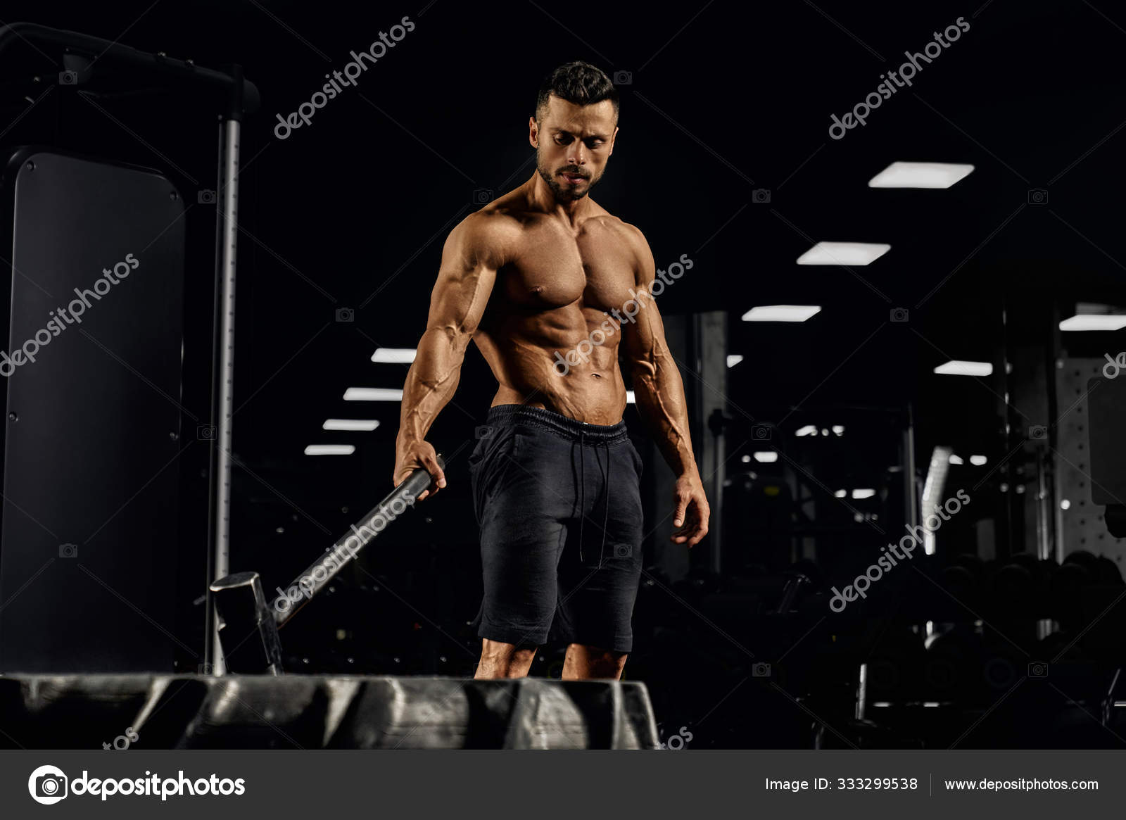 Shirtless bodybuilder carrying sledgehammer in gym. Stock Photo by ...