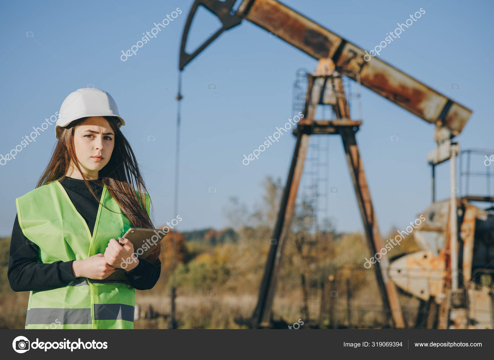 Woman engineer in hardhat is using a tablet computer. Industry ...