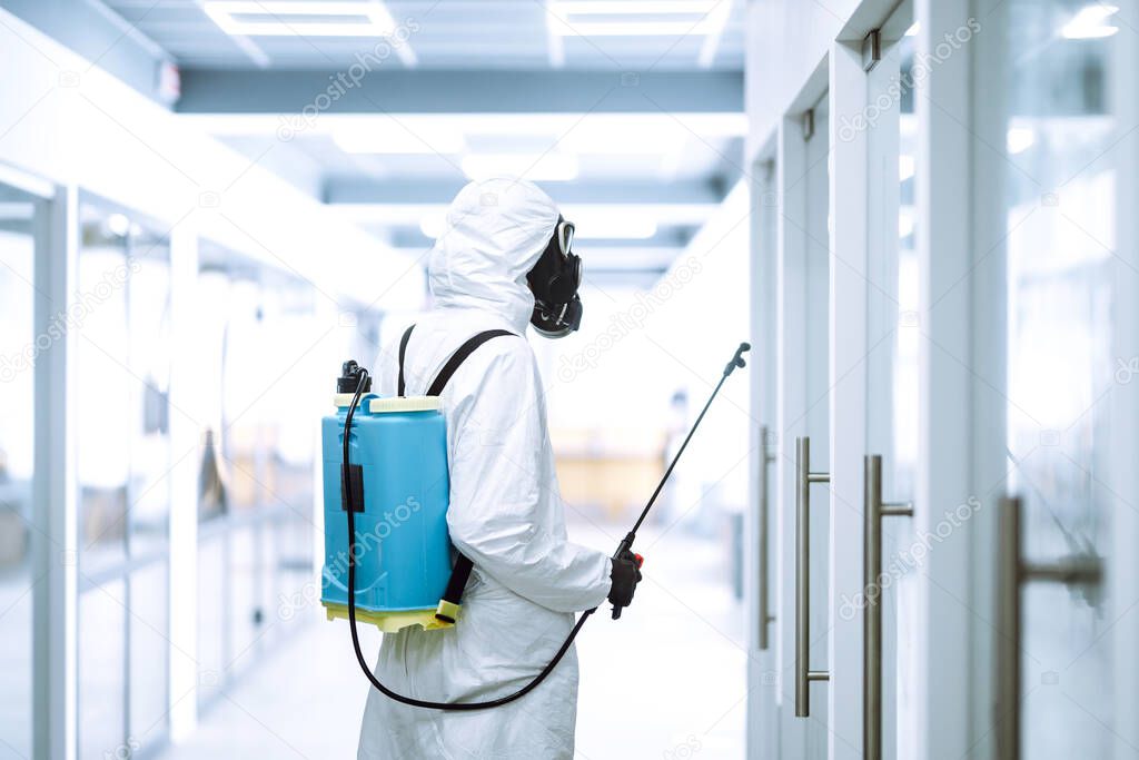 Desinfección de la oficina para prevenir COVID-19, Hombre en traje de ...