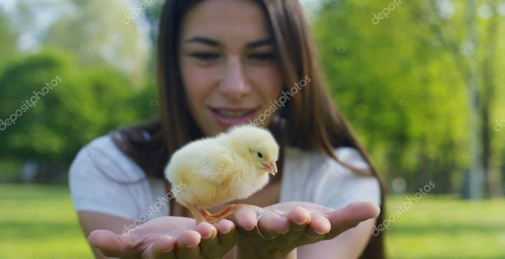 En un día soleado, sonriente joven hermosa niña sosteniendo un pequeño ...