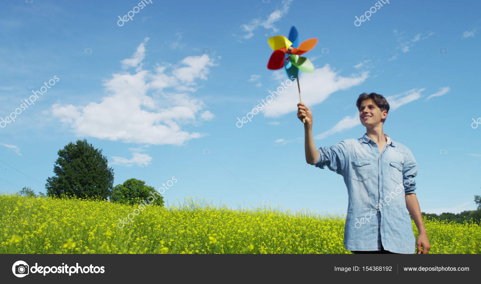 In a day of sun and wind, a happy nice beautiful kid in green nature ...