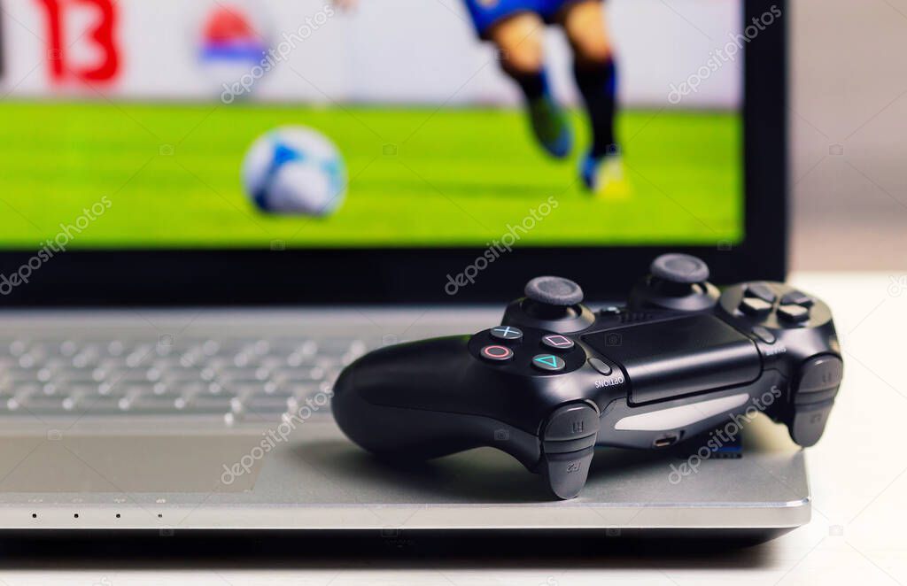 El mando negro está en el teclado de un portátil. Gamer portátil ...