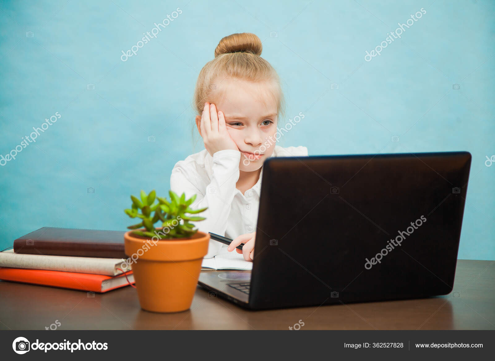 Sad tired elementary student girl homeschooling on laptop online Stock ...