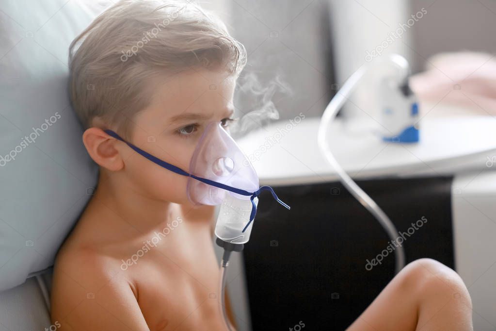 Niño tomando terapia respiratoria por inhalación en casa 2024