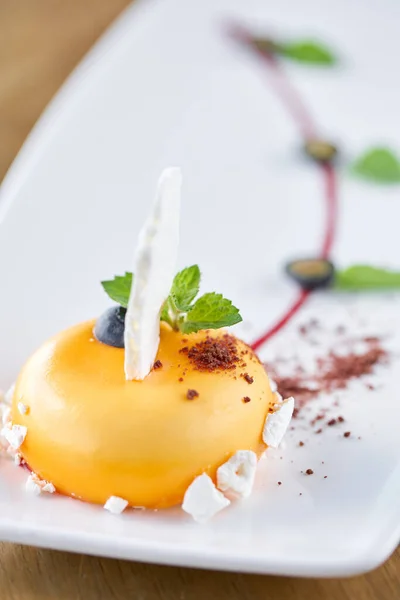 Pastel de mousse amarillo. Postre francés, arándanos, menta y un trozo ...