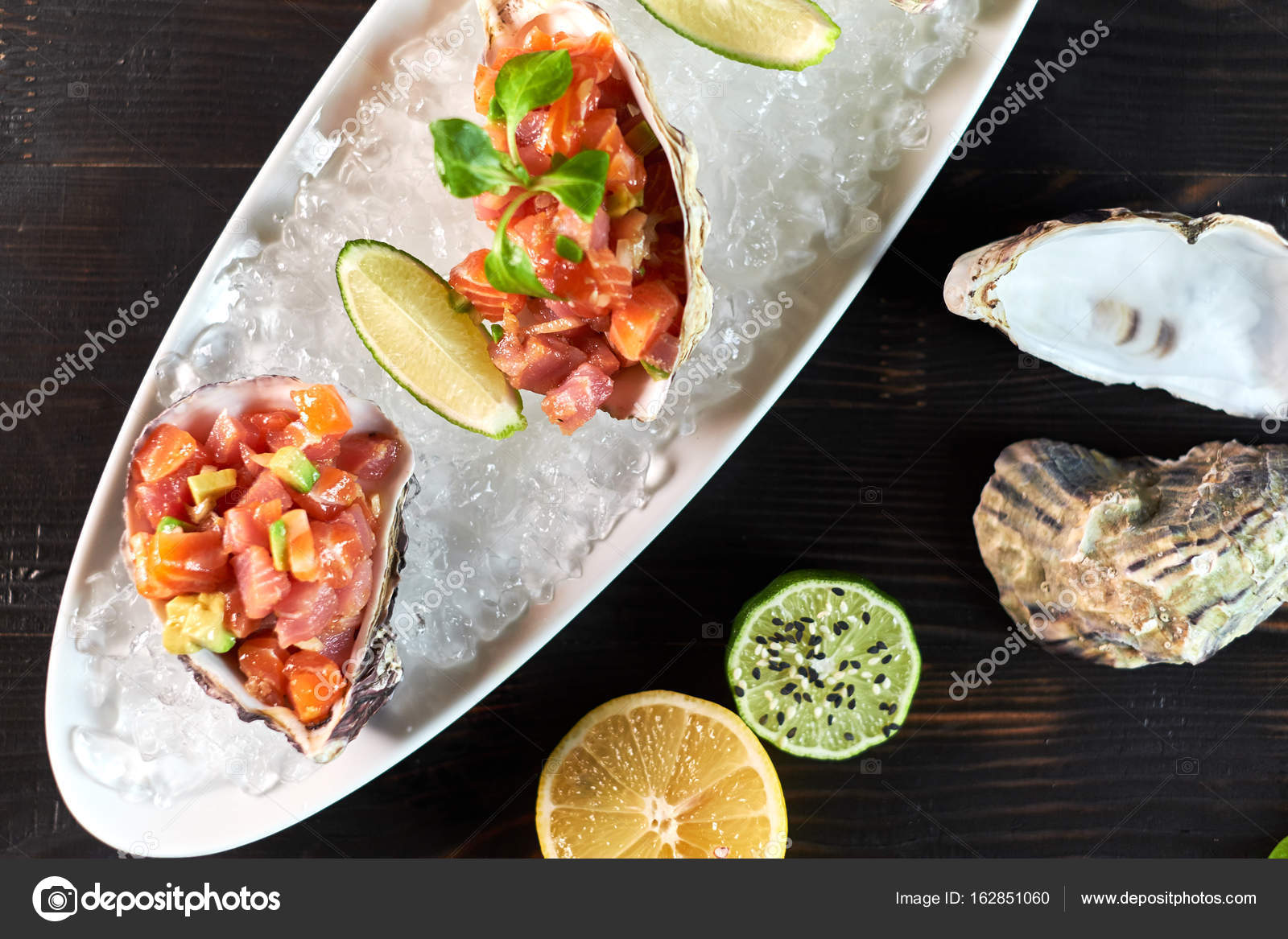 Delicious red fish in the shells of shellfish. With lemon and lime jpg ...