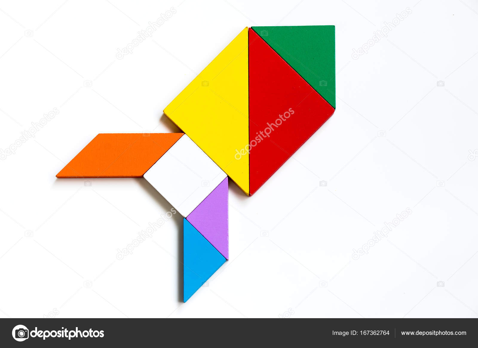 Colorful wood tangram puzzle in rocket or missile shape on white ...