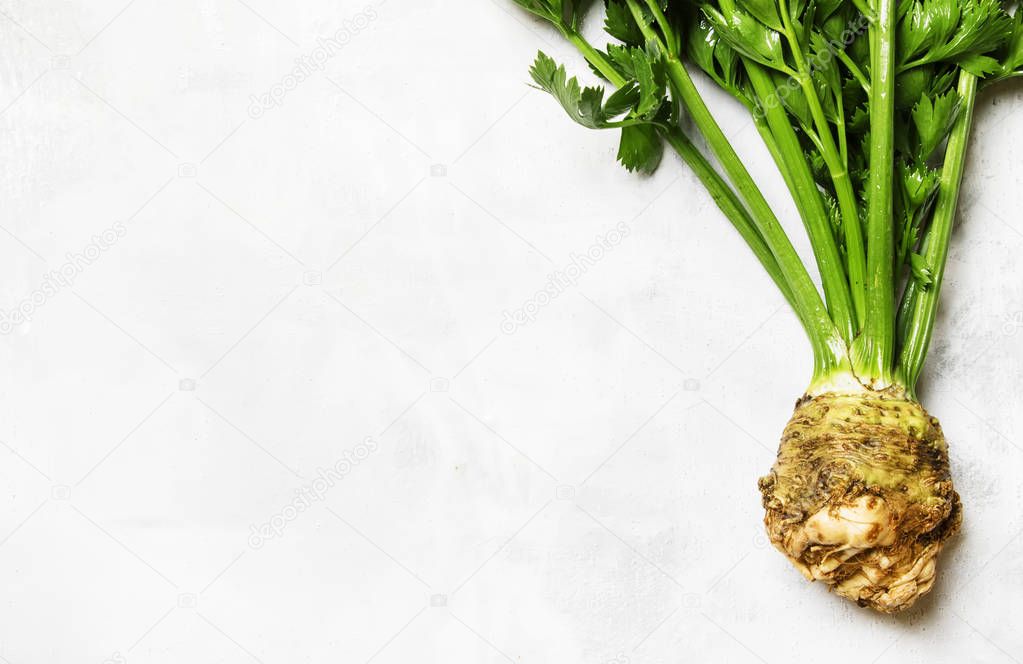 Apio de raíz con tallos verdes, fondo gris, vista superior 2023