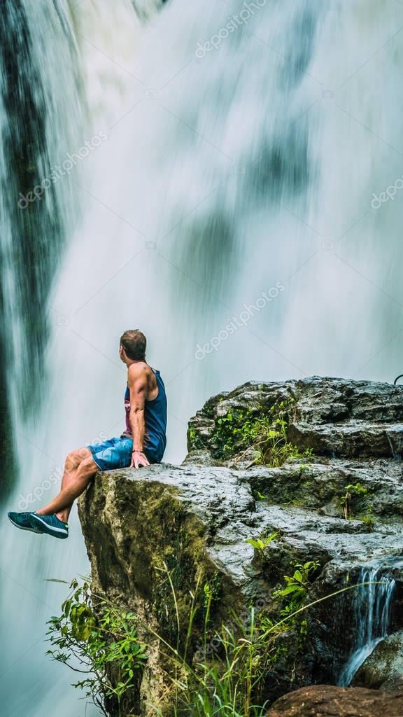 Hombre sentado frente a la cascada de Tegenungan cerca de Ubud en Bali ...