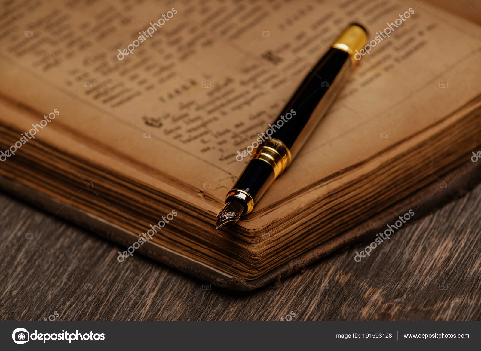 Old book and an ink pen on a wooden background. Stock Photo by ...