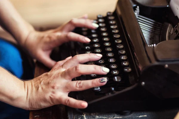 Woman typing on the typewriter, closeup. Fingers on the keys of a ...