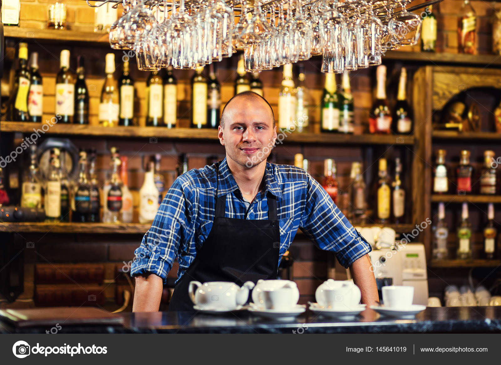 Barman at work in pub,Portrait of cheerful barman worker standing ...
