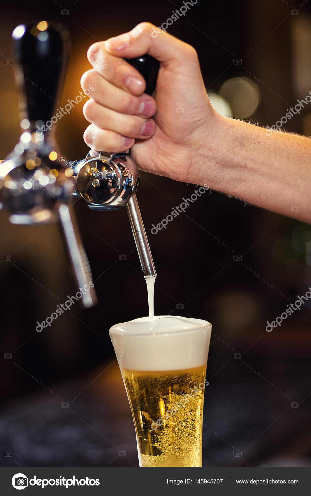 Bartender pouring the fresh beer in pub,barman hand at beer tap pouring ...