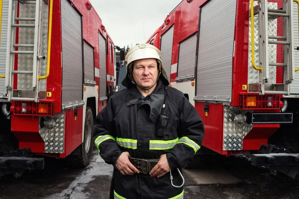 Fireman (firefighter) in action standing near a firetruck. Emergency ...