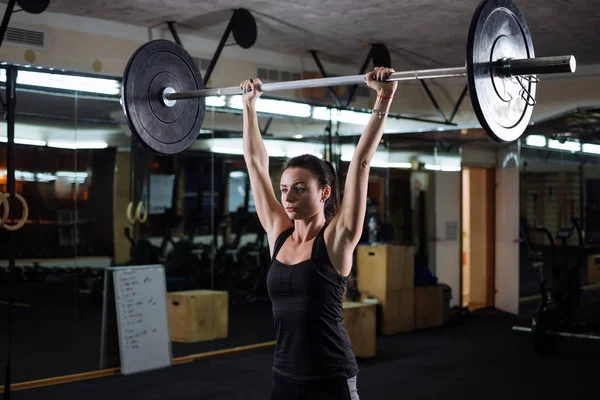 Pretty young woman lifting weights at the gym - Stock Image - Everypixel