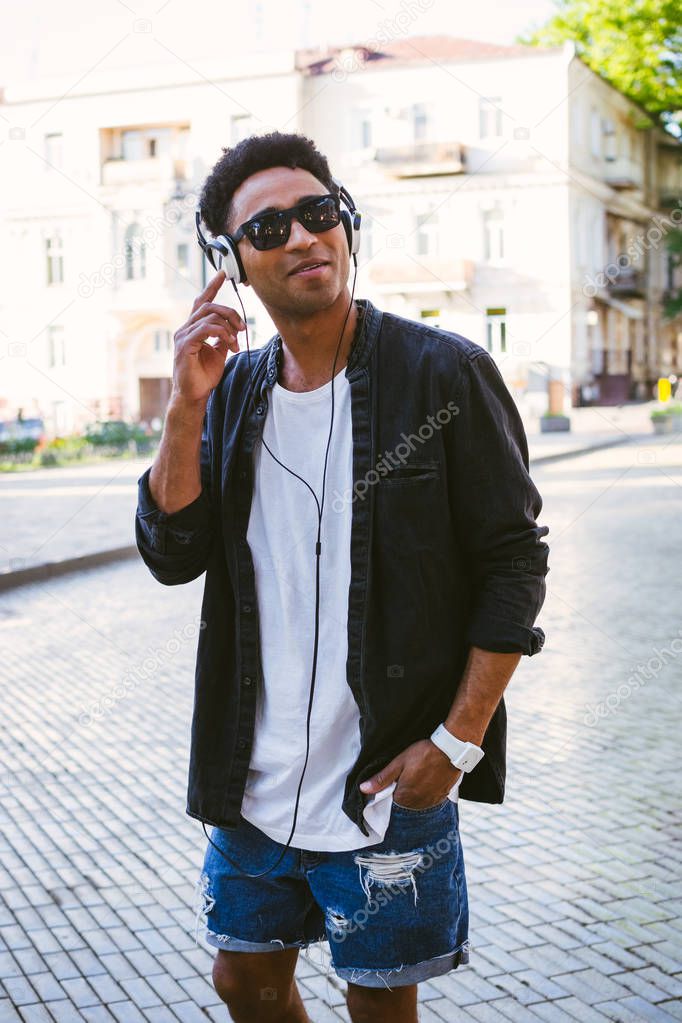Portrait of young stylish hipster black man in white headphones and sun ... Portrait of young stylish hipster black man in white headphones and sun ...