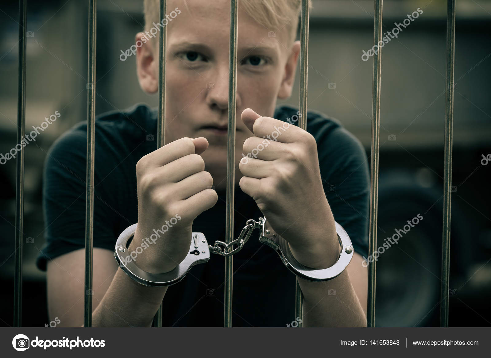 Handcuffed teenage boy behind bars — Stock Photo © jhandersen #141653848