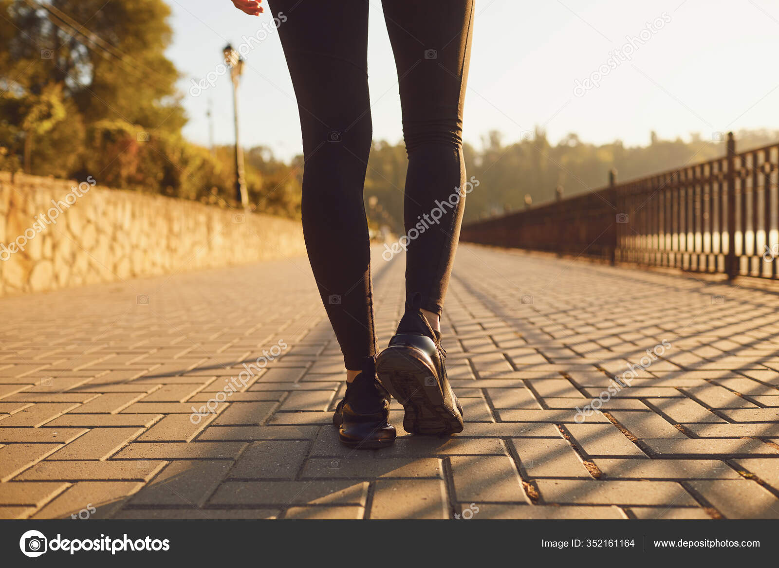 Rear view of a runner walking on a road in a park Stock Photo by ...
