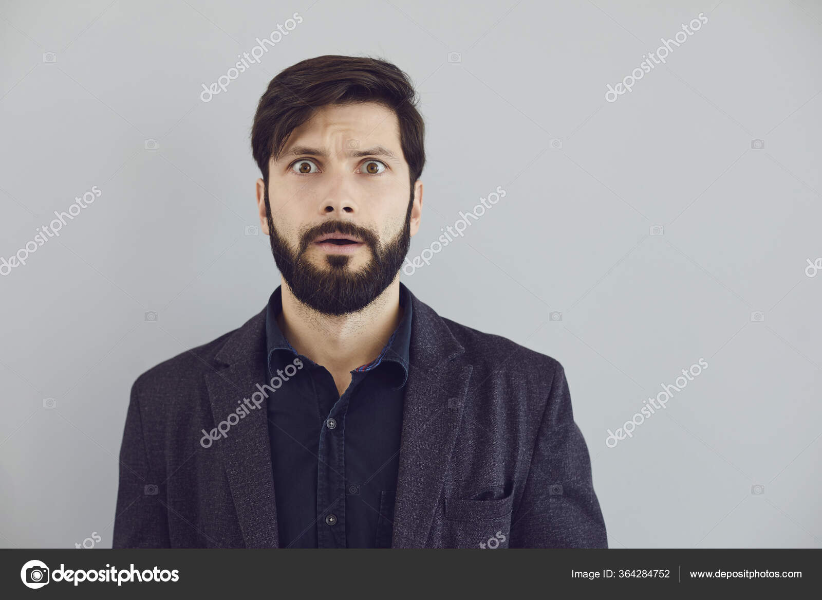 Puzzled insecure man in casual jacket on a gray background. Expression ...