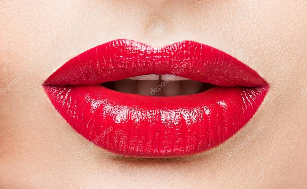 Los labios femeninos que se componen de lápiz labial rojo. 2023