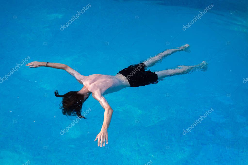 Joven flotando y divirtiéndose en la piscina 2024