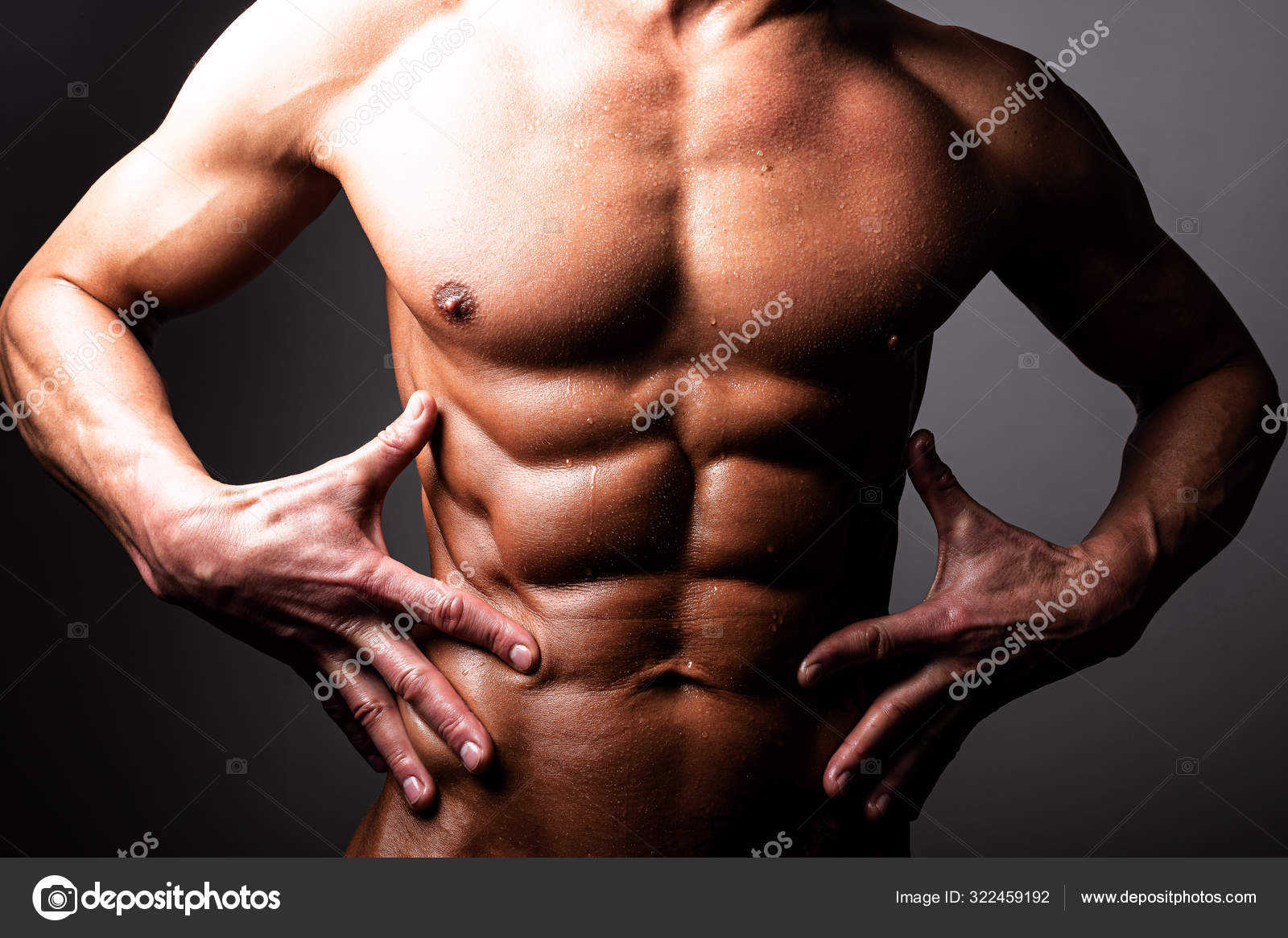Beautiful, athletic, male torso. In contrast lighting. A man holds his ...