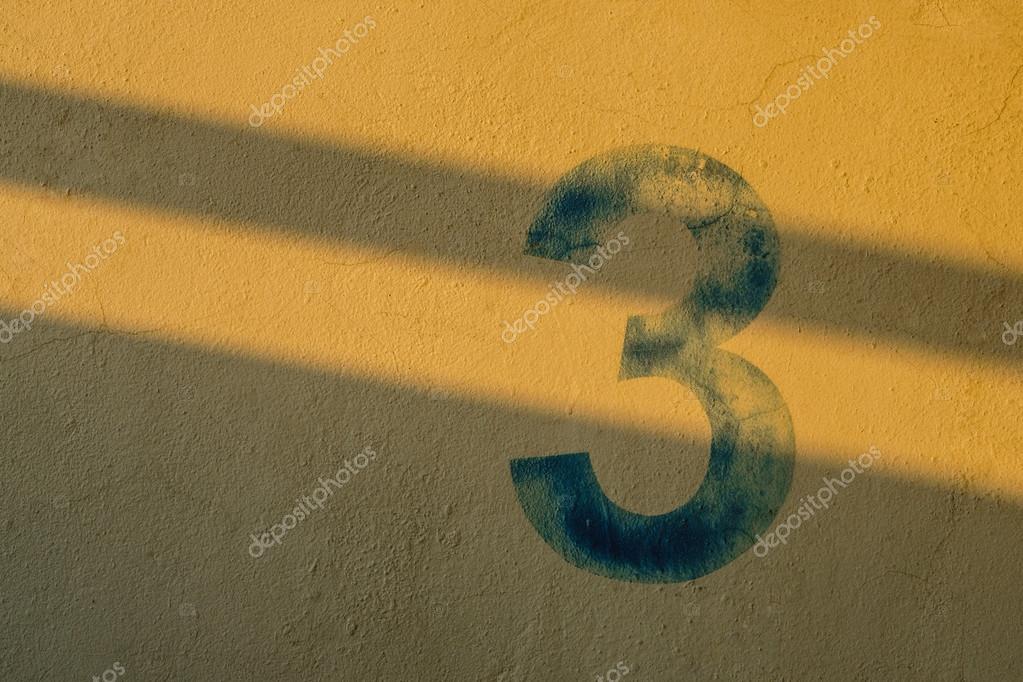 el número 3 en la pared bajo la sombra de las luces 2022