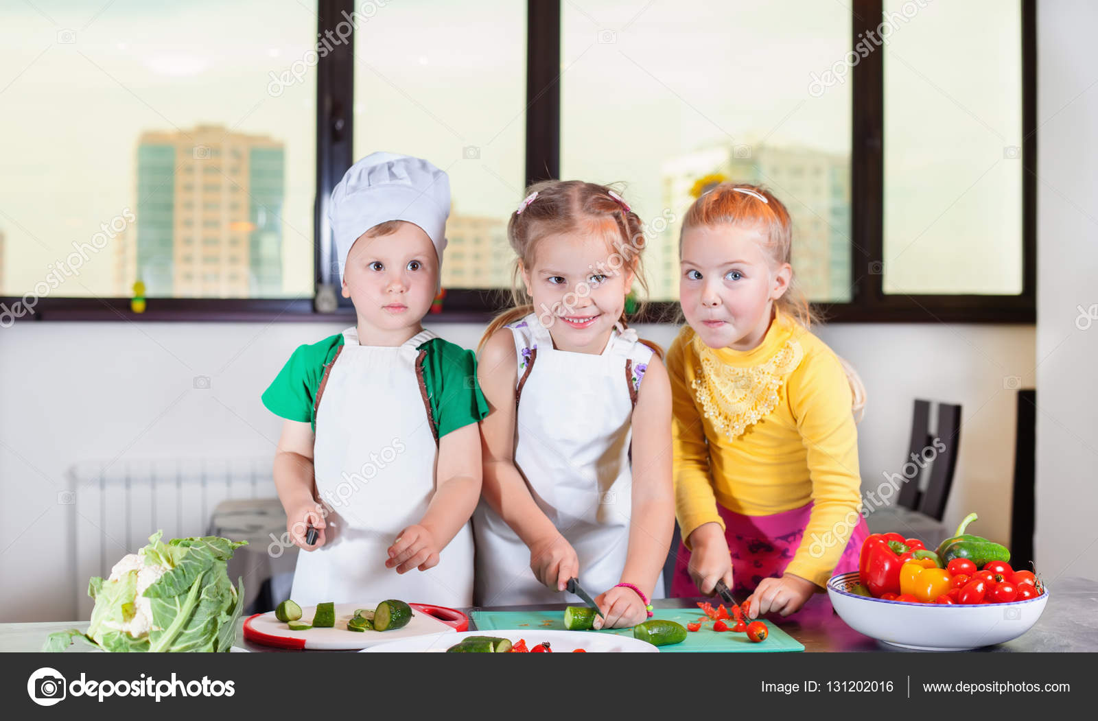 Three cute kids are preparing a salad in the kitchen — Stock Photo ...
