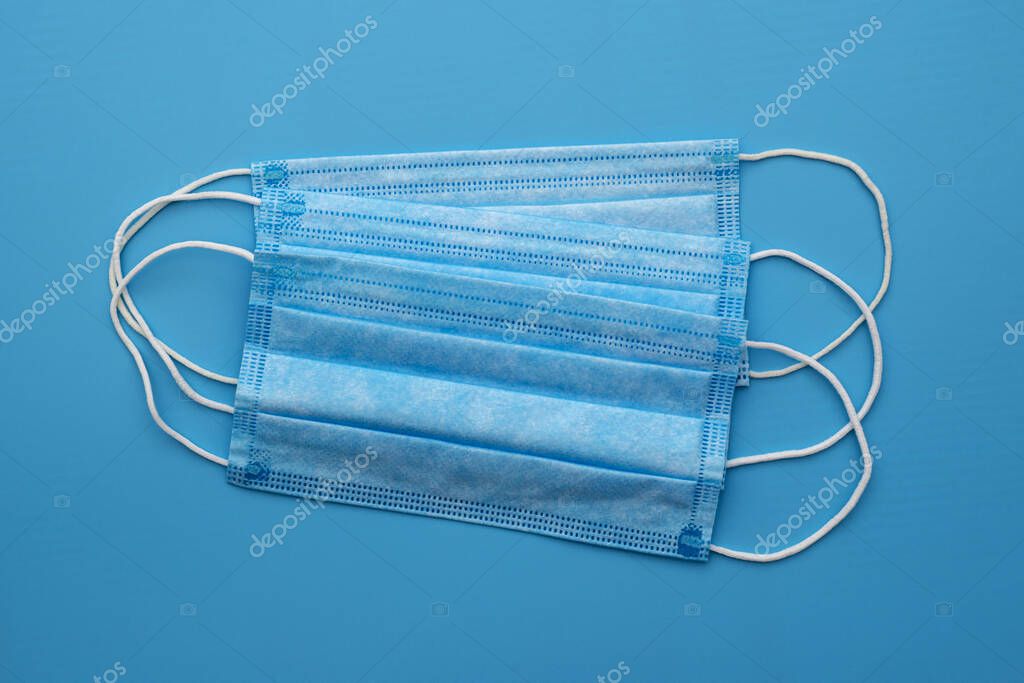 Máscaras protectoras médicas sobre fondo azul. La mascarilla quirúrgica ...