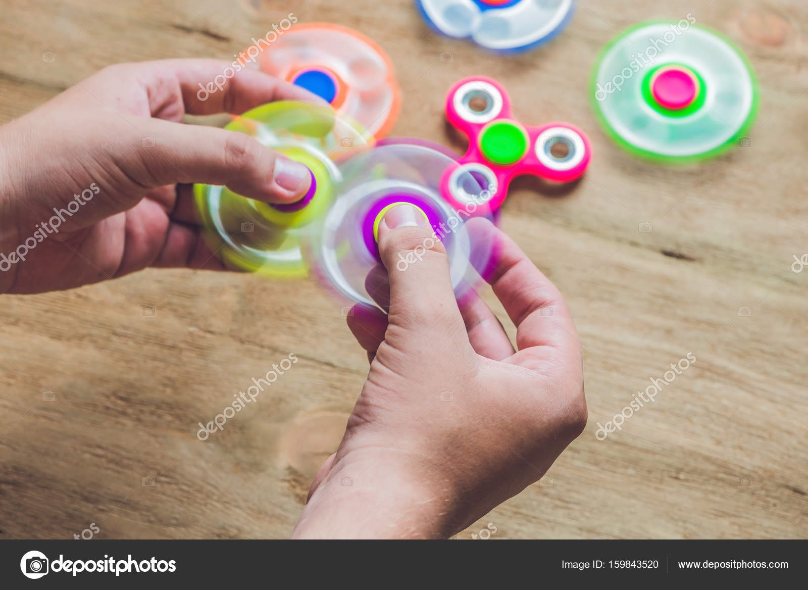 Hands holding hand spinner Stock Photo by ©galitskaya 159843520