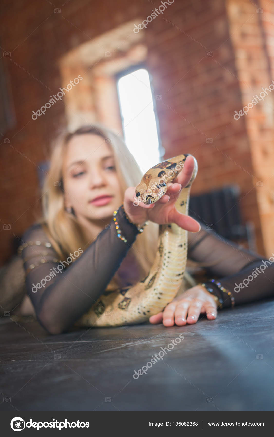 Elegant blonde woman lying on the bed with python — Stock Photo ...
