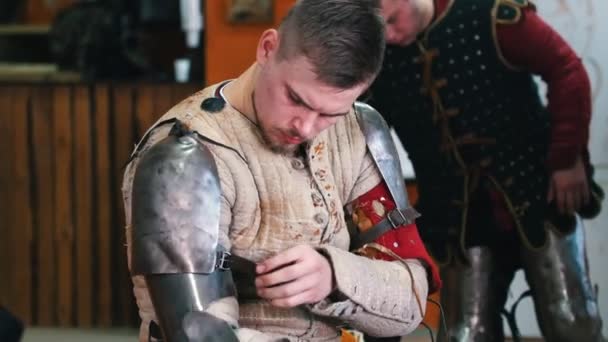 Knights training - men putting on a full armour before a training fight ...