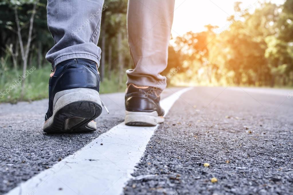 Los pies del hombre en el camino y la naturaleza de fondo 2023