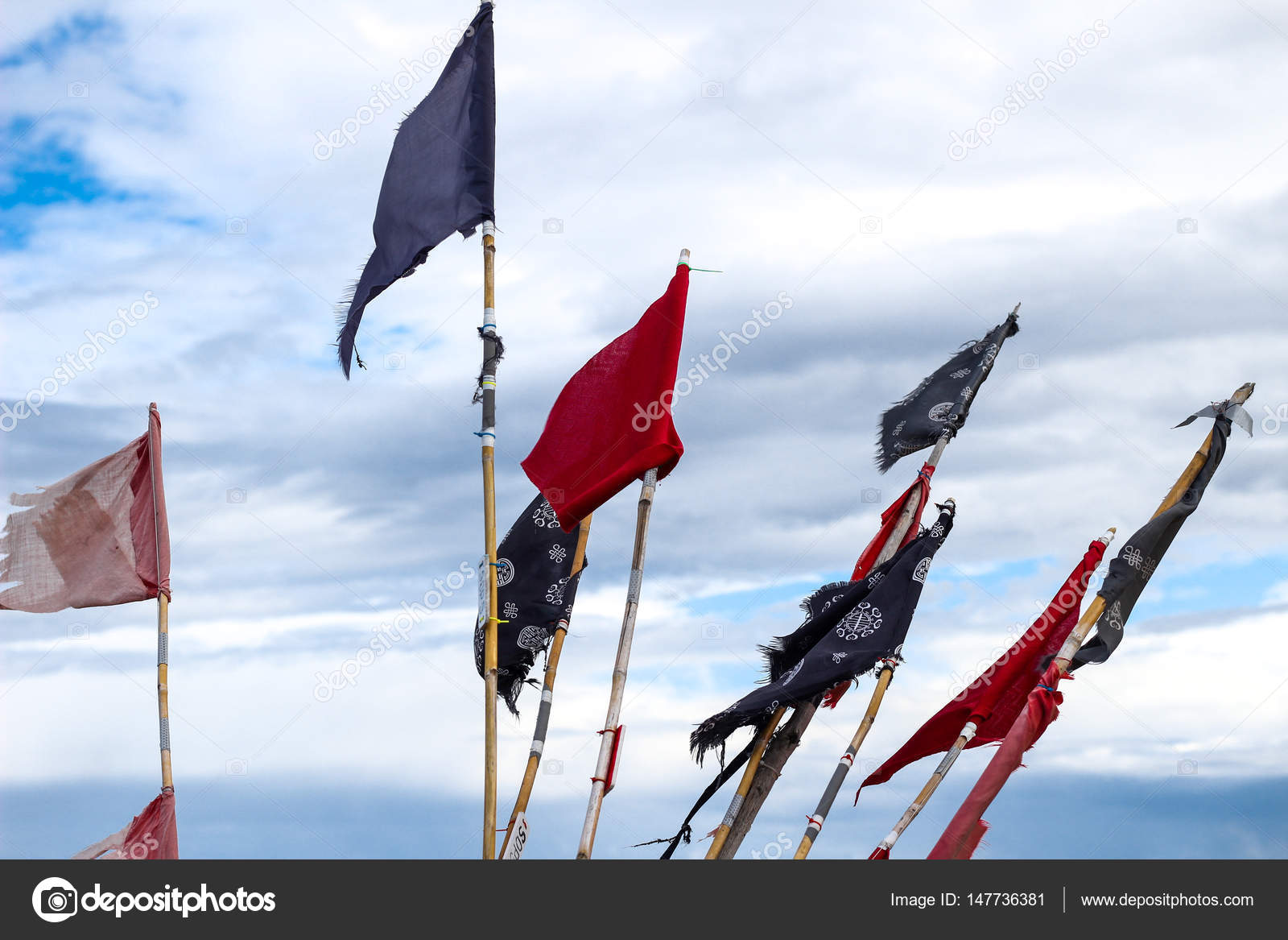 Colorful red blue and black flags on a boat or ship against blue ...
