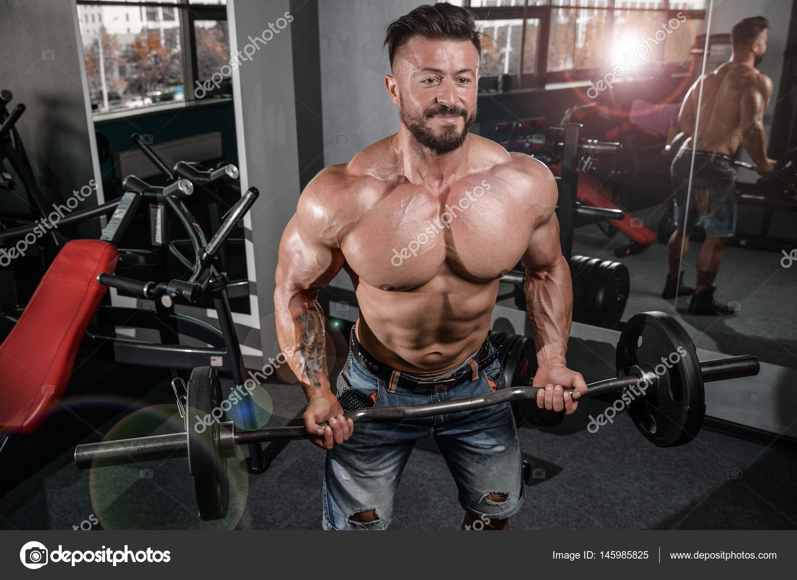 Brutal strong bodybuilder man pumping up muscles and train gym Stock ...