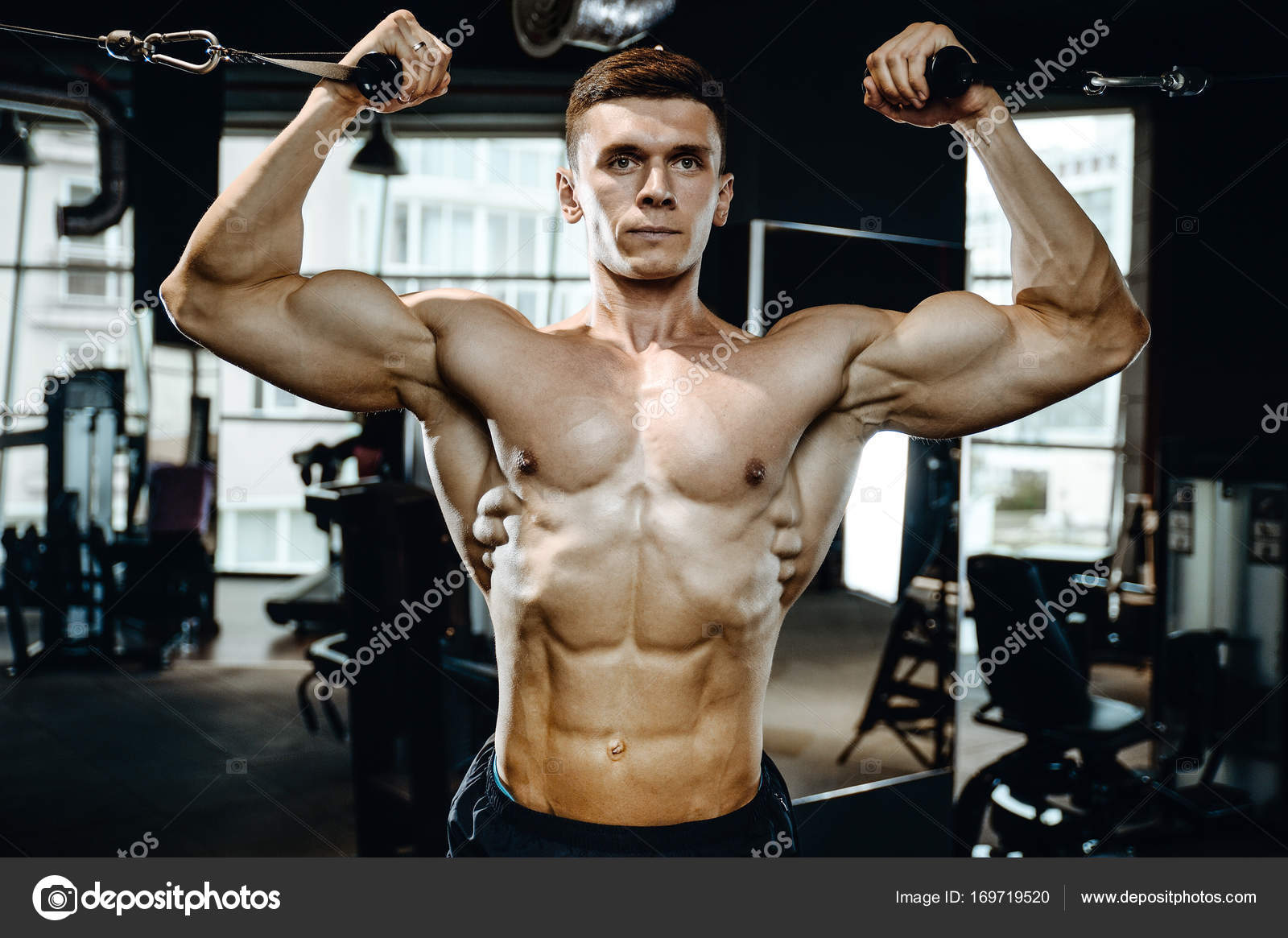 Handsome model young man training arms in gym Stock Photo by ...