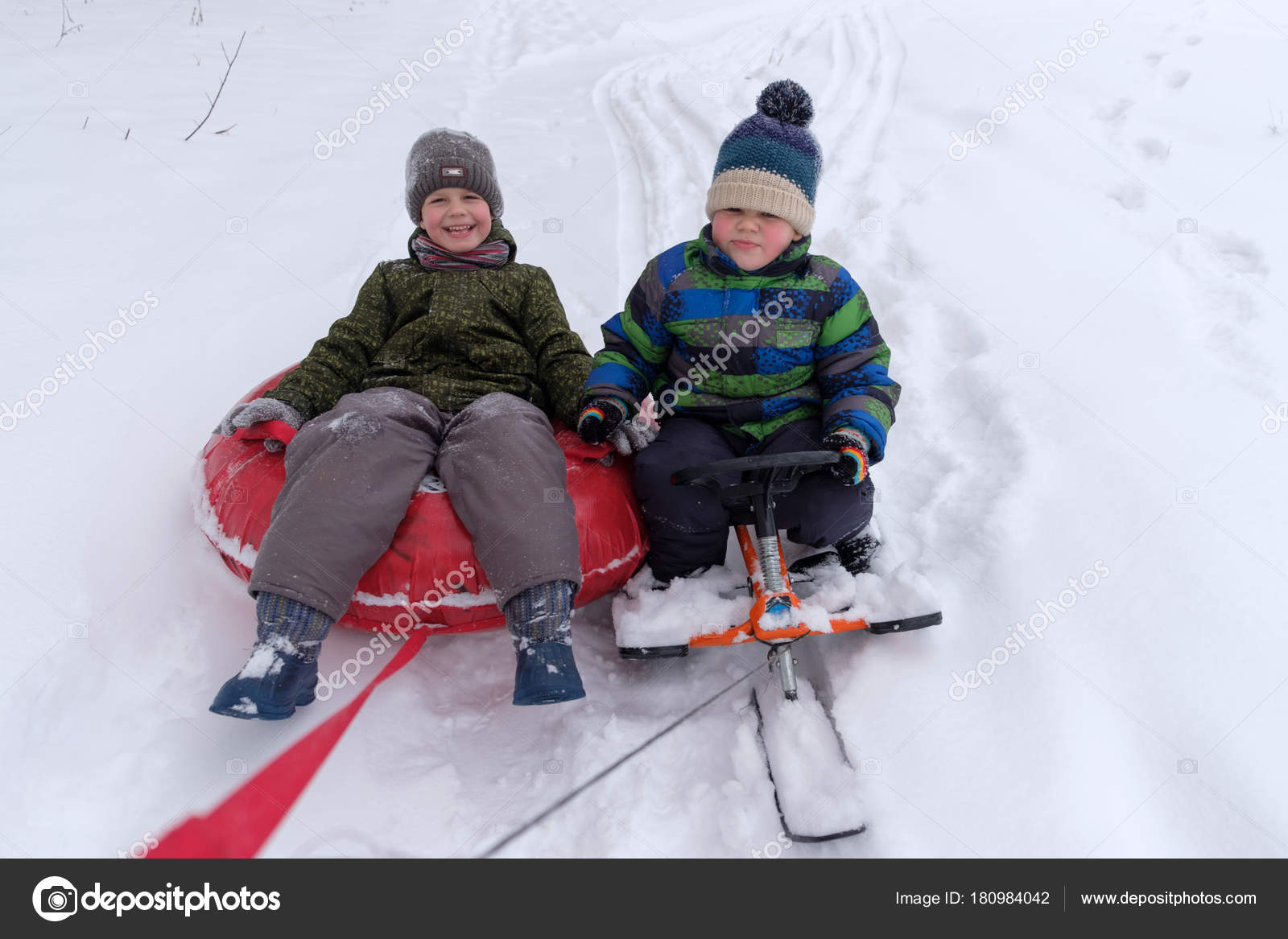 Two boys go snow sledding and tubing — Stock Photo © androsov58 #180984042