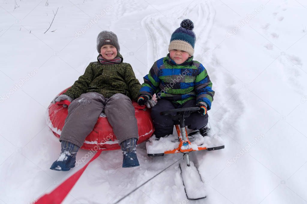 Two boys go snow sledding and tubing — Stock Photo © androsov58 #180984042