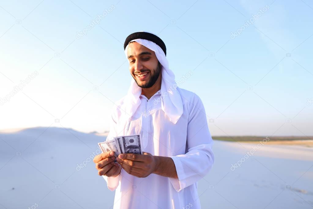 El exitoso jeque árabe considera los billetes y feliz, de pie i 2022