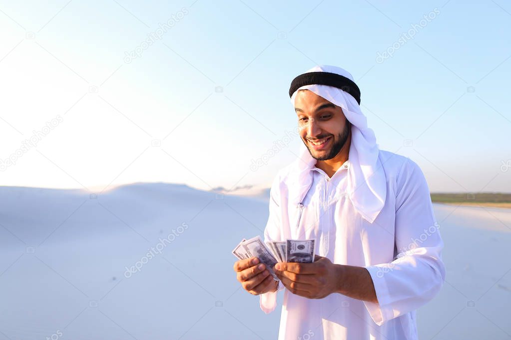 El exitoso jeque árabe considera los billetes y feliz, de pie i 2024