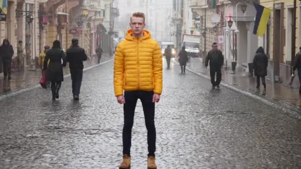 Timelapse of Young man standing still at sidewalk in crowd traffic ...