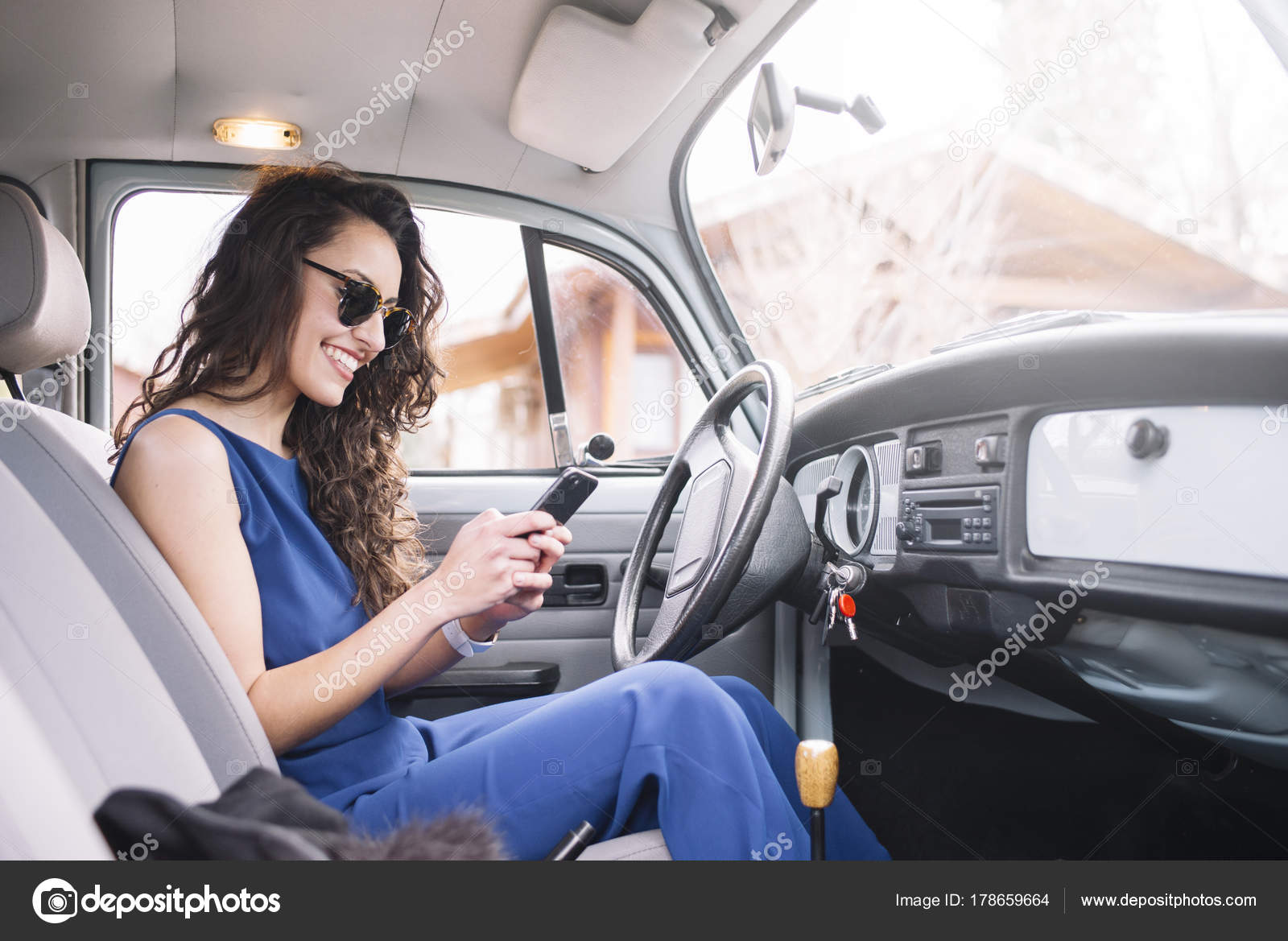 Beautiful young woman using her mobile phone in the car. Stock Photo by ...